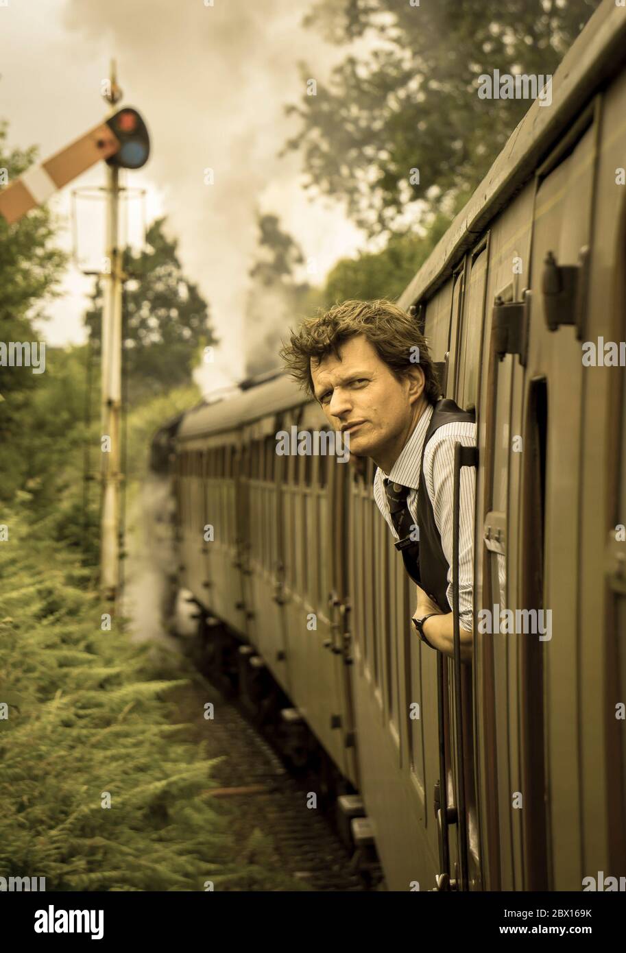 Retro close up of isolated train guard leaning & looking out of window ...