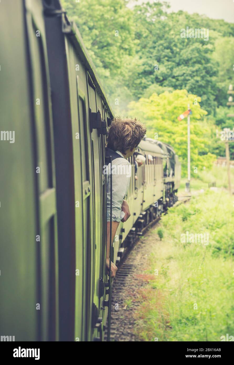 Retro rear view close up of isolated train guard leaning & looking out ...