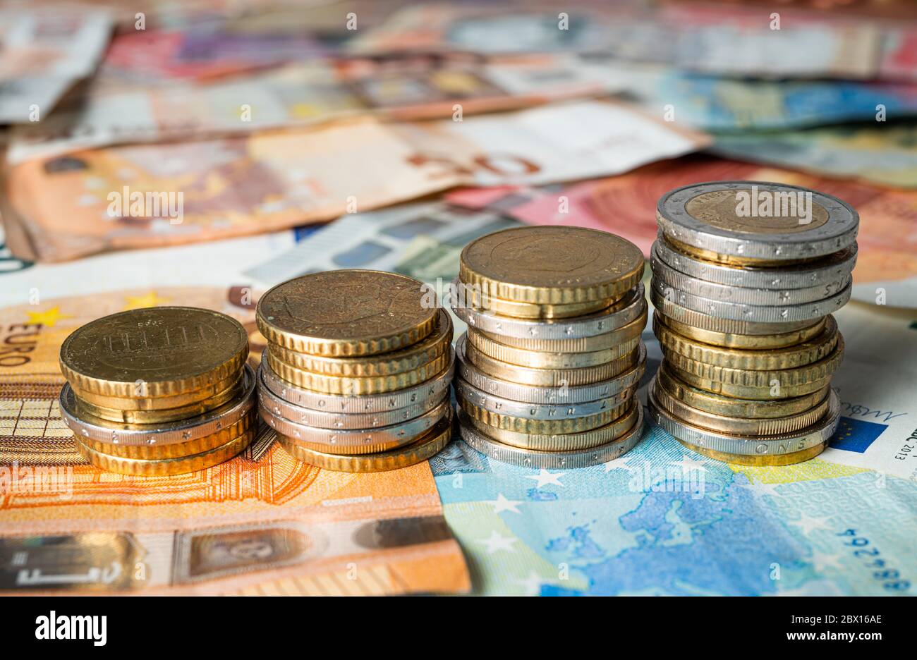 Chart of stacked Euro coins on several Euro bills visualising inflation ...