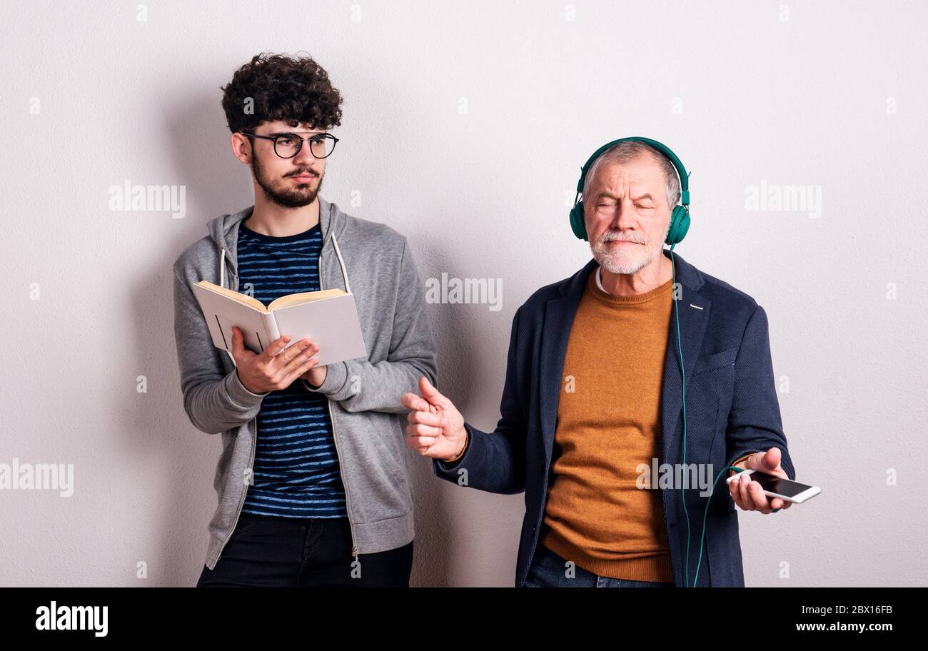 Studio shot of young versus old generation, technology addiction ...