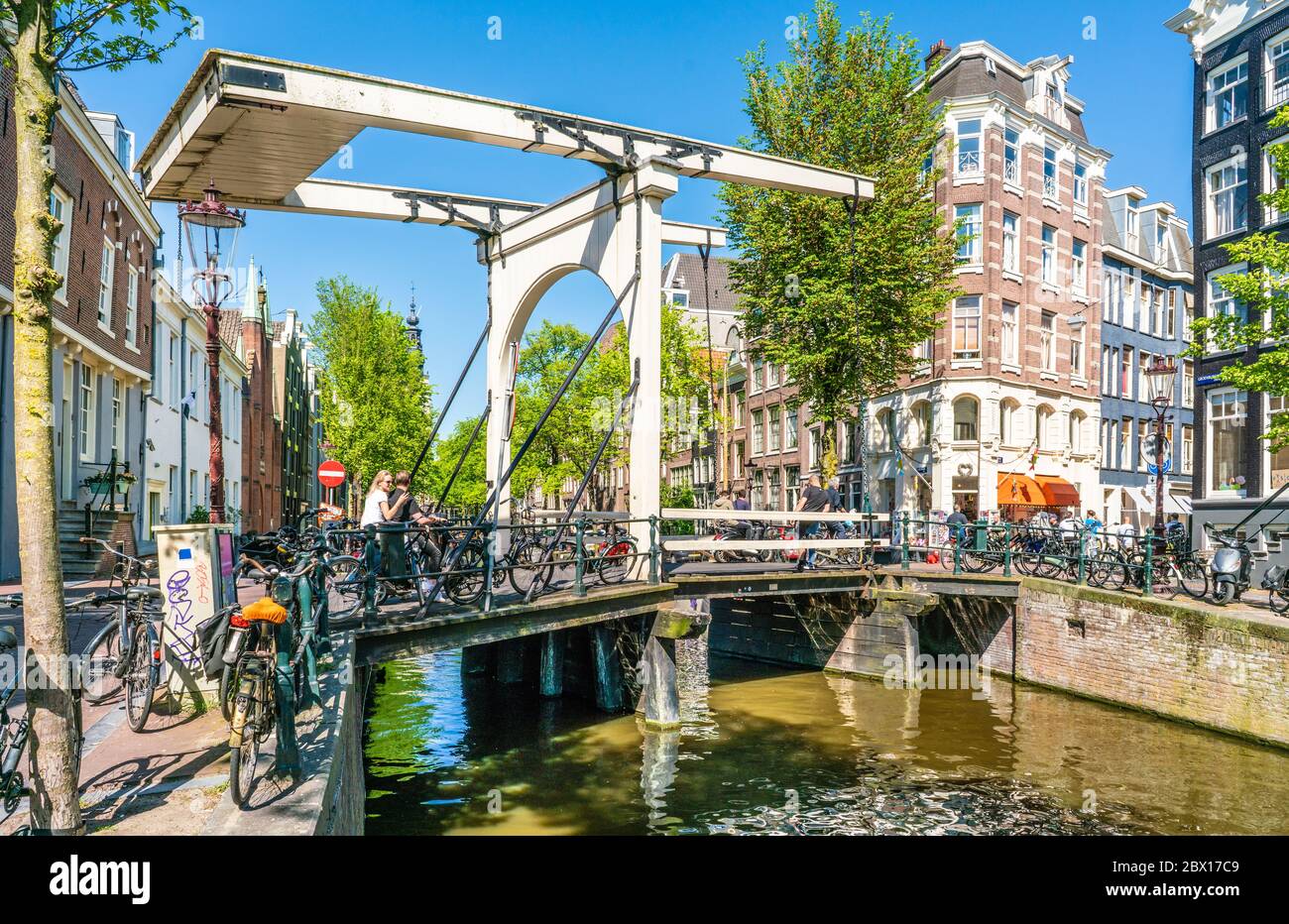 Amsterdam, May 7 2018 - tourist crossing the Groenburgwal over the ...