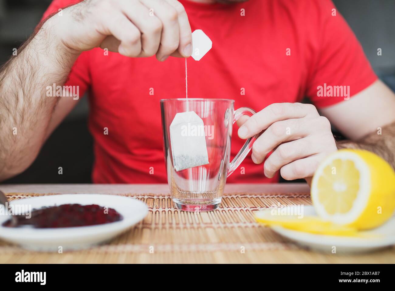 Putting tea bag into glass cup - morning hot drink Stock Photo - Alamy