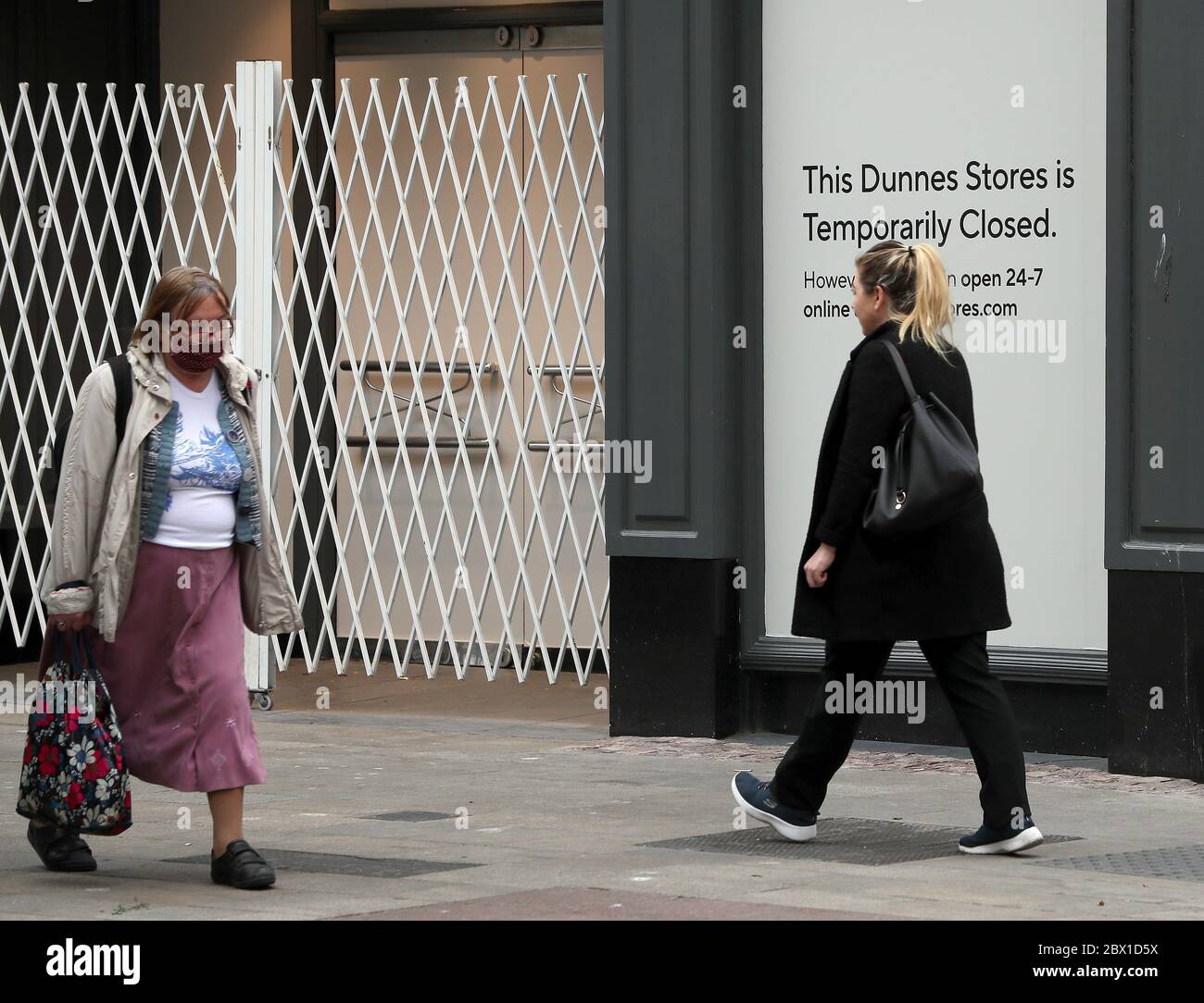 People pass a closed Dunnes Stores on Dublin's Grafton street as it is ...