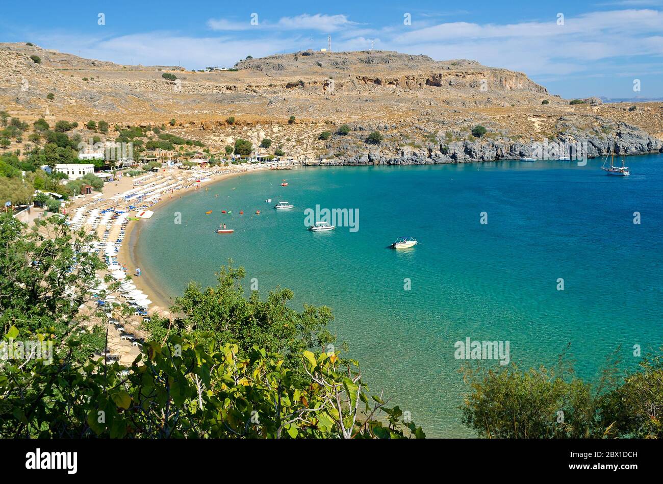 Lindos Bay, Rhodes with boats floating on the crystal clear water Stock ...