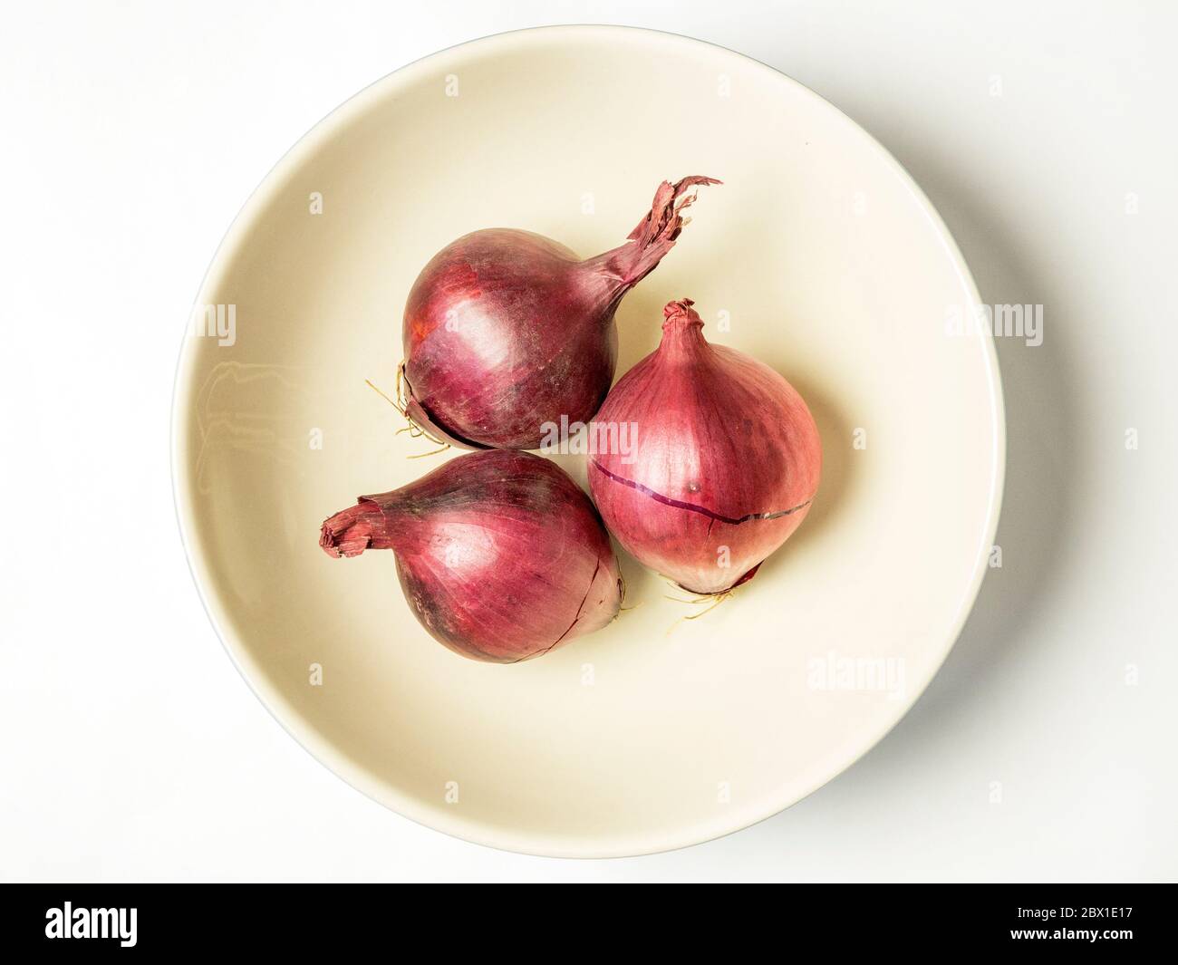 Three small red onions in a bowl isolated on a white background Stock ...