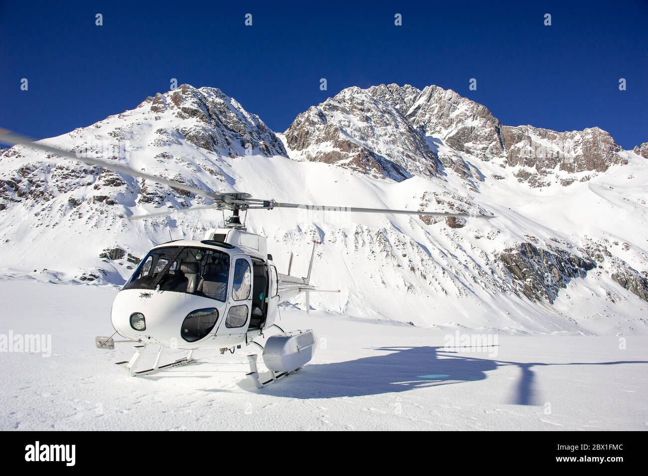 Helicopter landed on a mountain top. White helicopter against a white ...