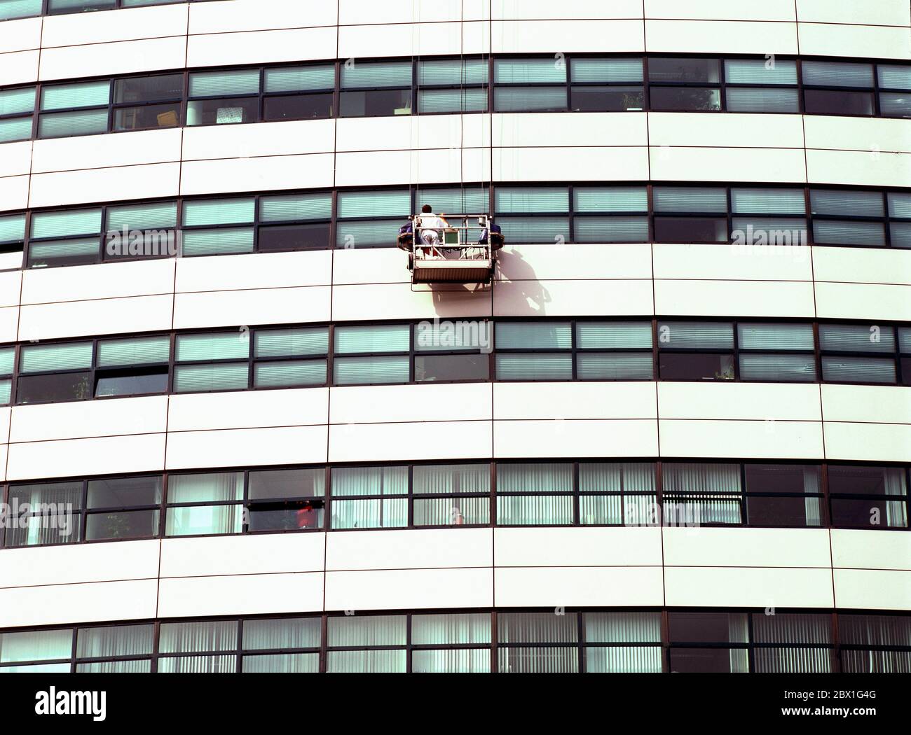 Window cleaner at work in a scaffold on side of skyscraper Stock Photo ...