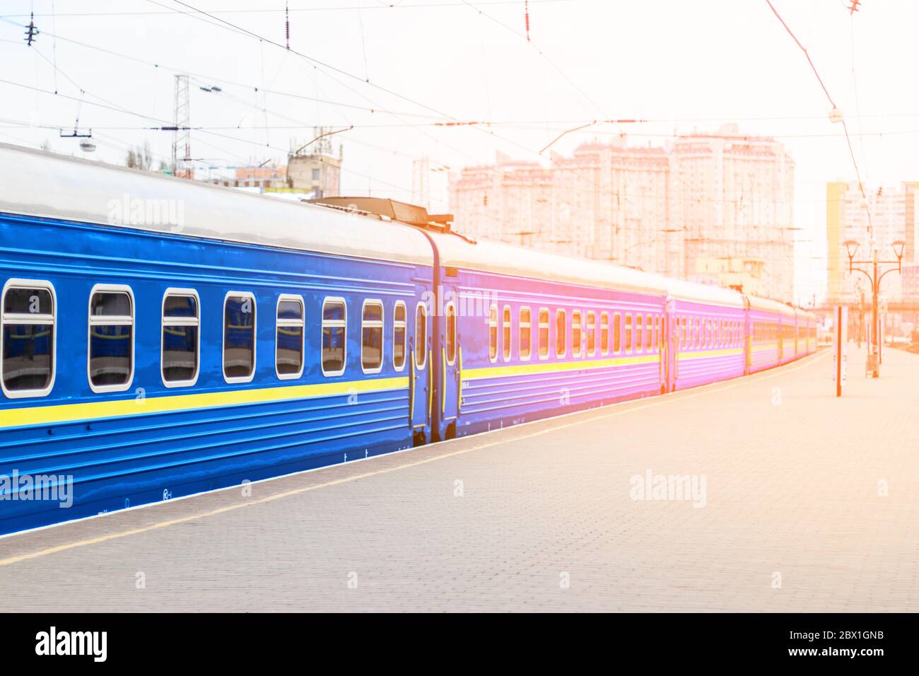 local train at the railway station in the sunset sunlight. Train on a ...