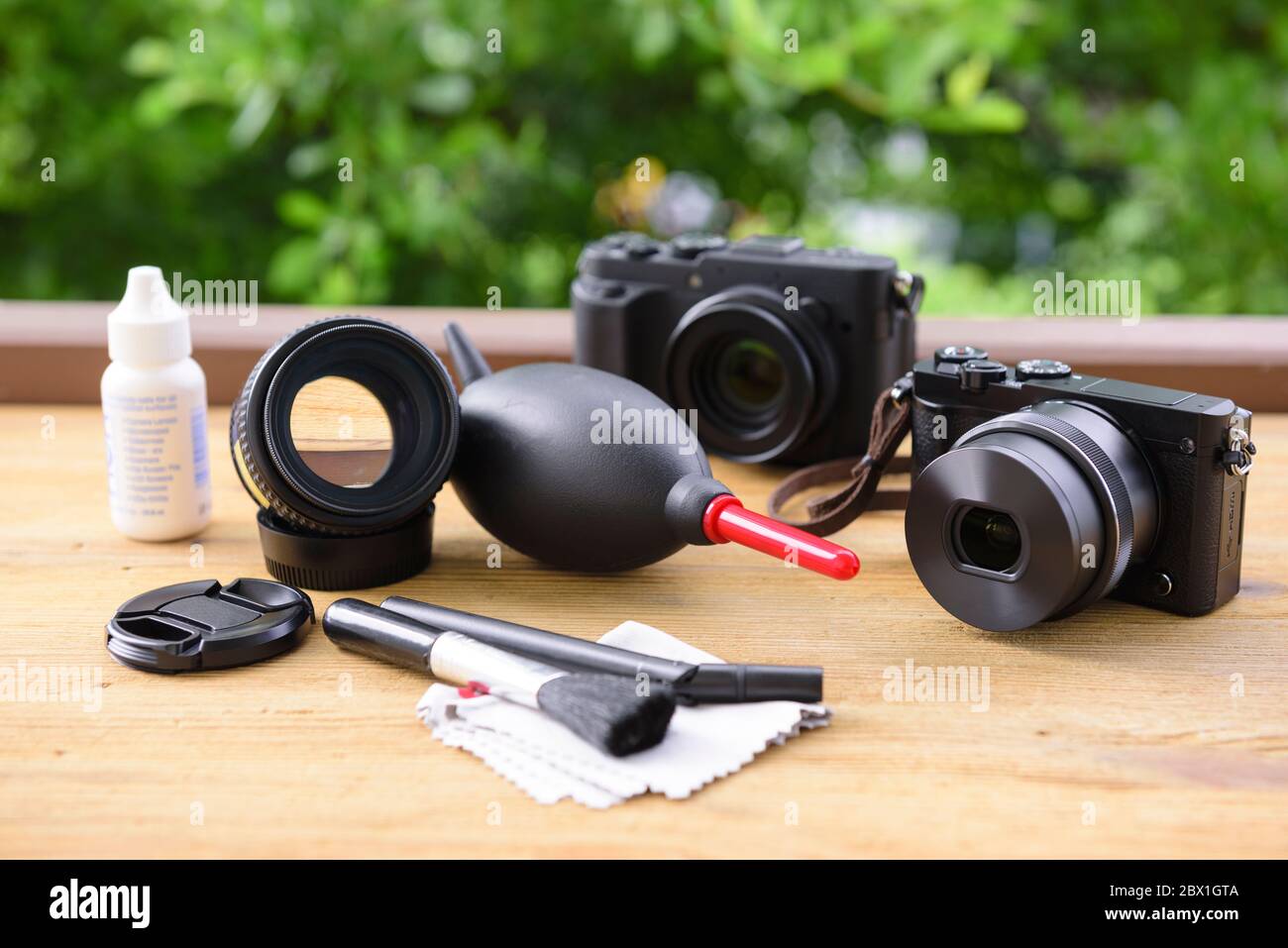 Camera and lens care. Camera cleaning kits and camera gears on wooden ...