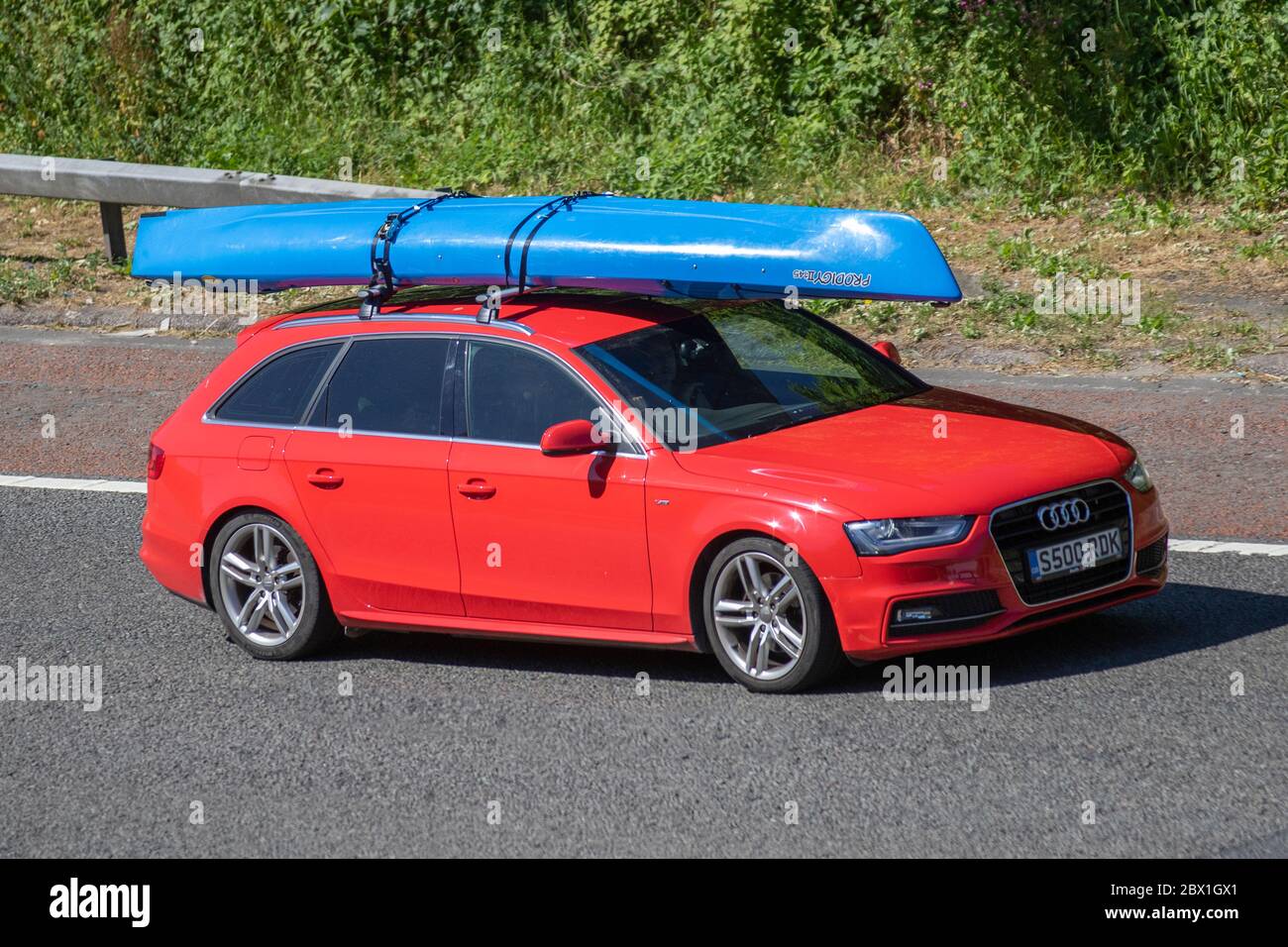 2015 red Audi A4 S Line TDI CVT 5dr estate carrying blue Prodigy canoe ...