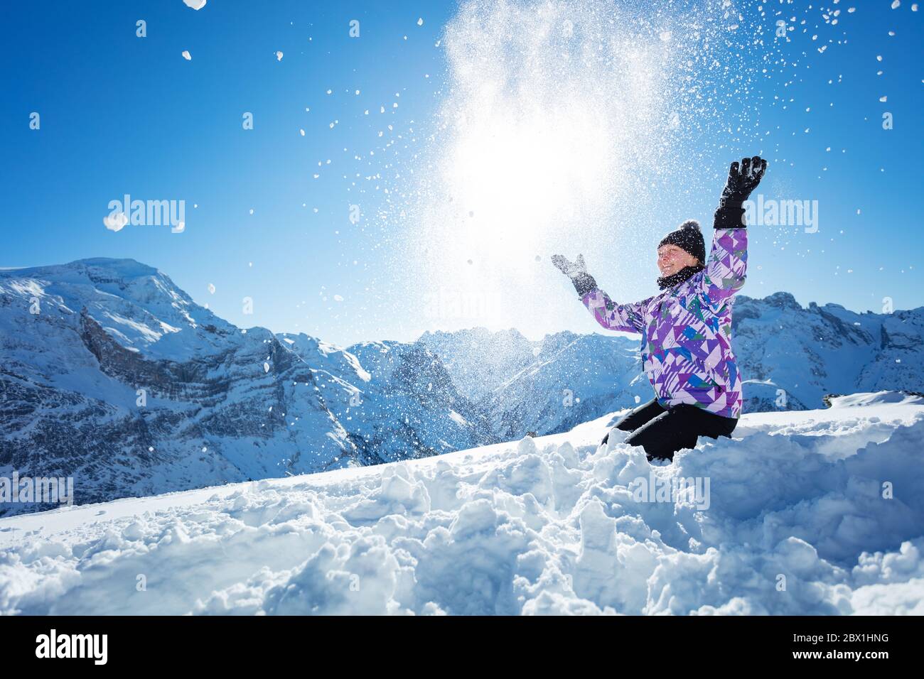 Happy teen beautiful ski girl portrait throw snow in the air sitting ...