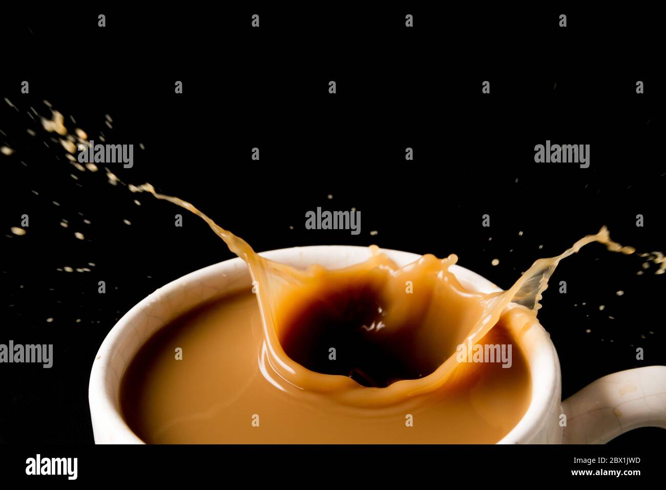 Cup of splashing coffee on black background Stock Photo - Alamy
