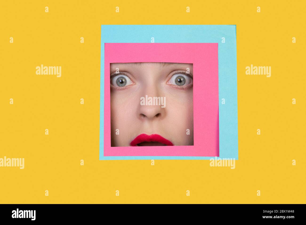 Scared. Face of emotional caucasian woman peeks throught square in ...