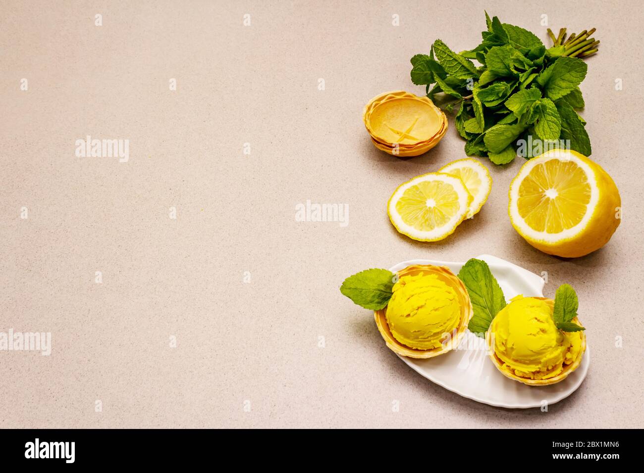 Lemon ice cream with mint. Refreshing summer dessert, ripe fruit, fragrant leaves. Stone ...