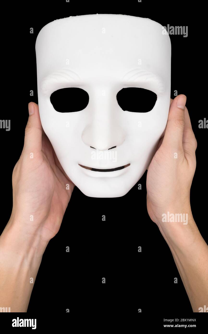 Hands holding white mask on black background Stock Photo - Alamy