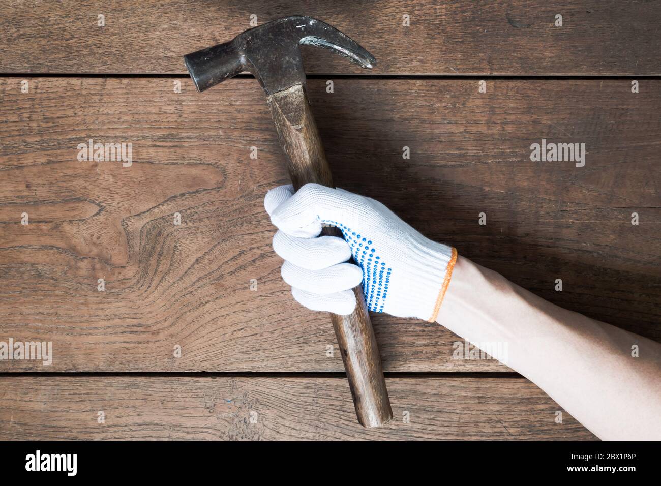 Hand holding hammer on wooden table background Stock Photo - Alamy