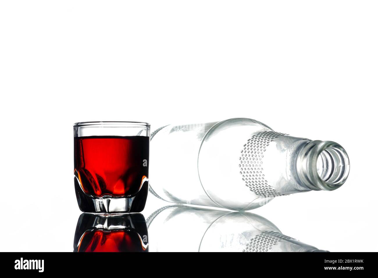 Glass of alcohol and empty bottle on a white background Stock Photo - Alamy