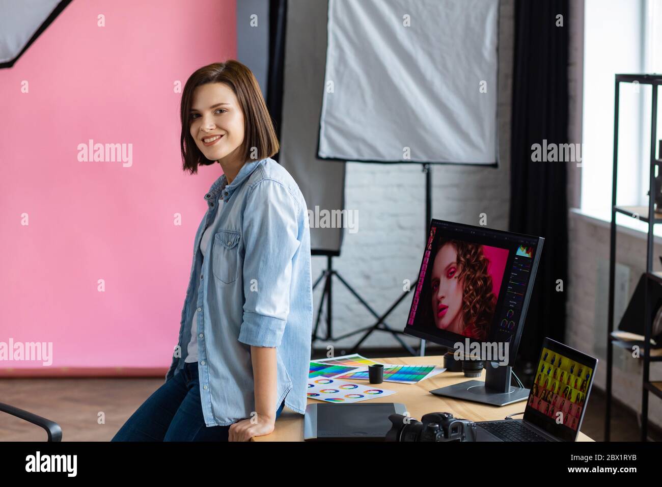 Portrait of graphic designer working in office with laptop,monitor ...