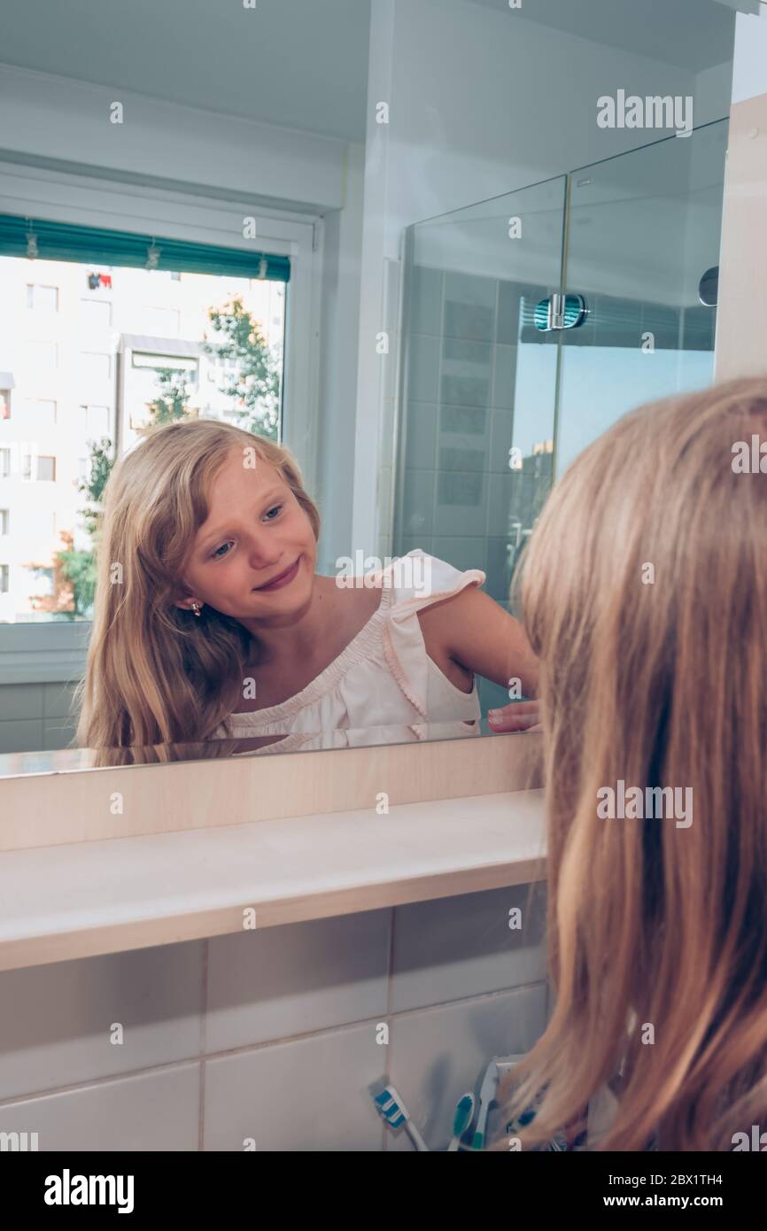 close up portrait of adorable girl with long blond hair in the bathroom ...