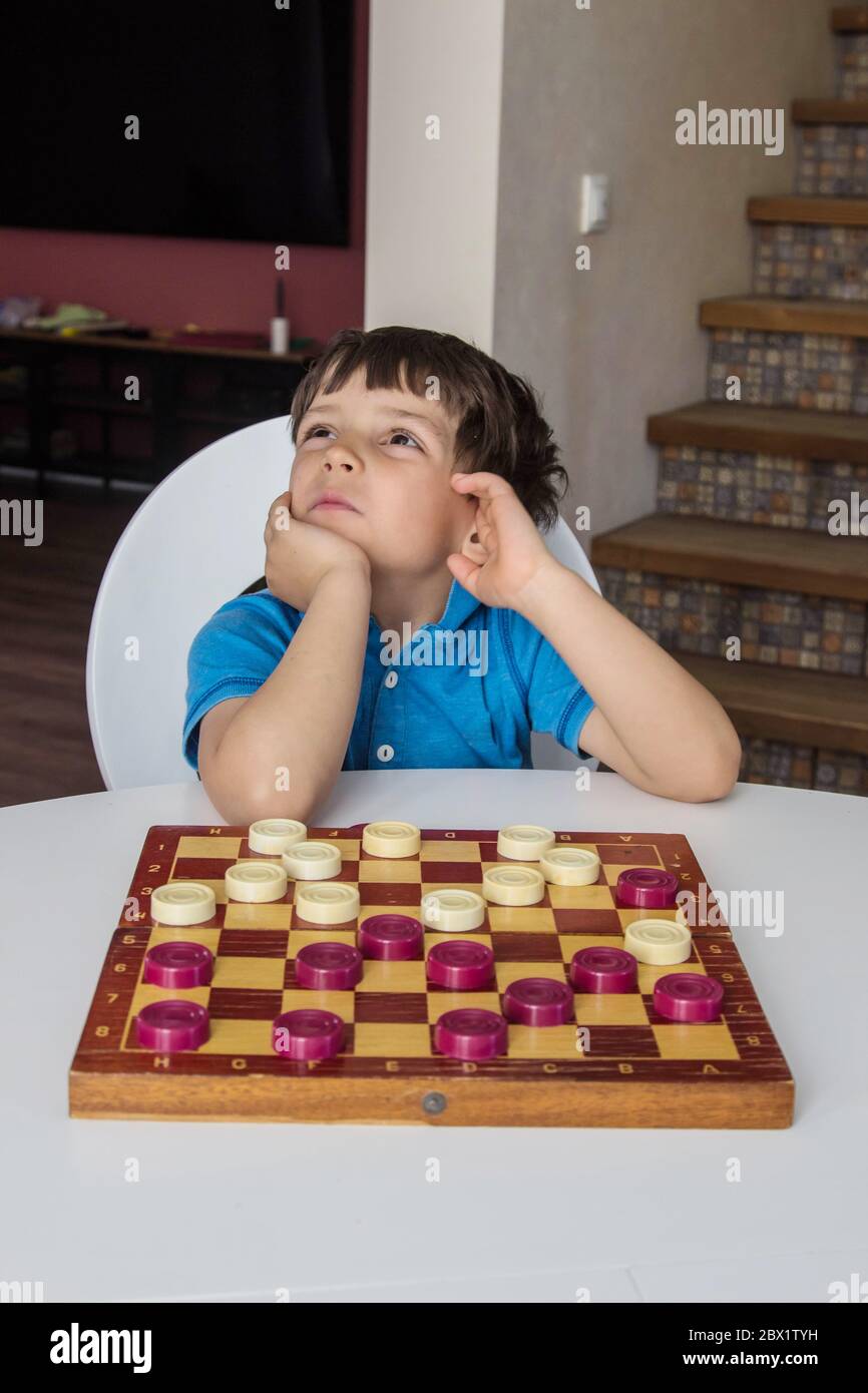 Smart child playing checkers at the table against an opponent Stock ...