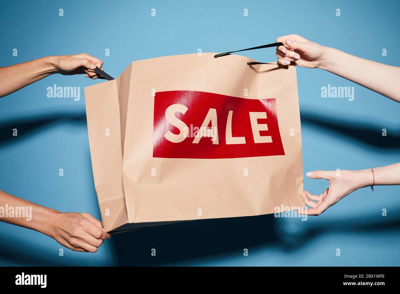 Close-up of two women pulling the bag in different directions against ...