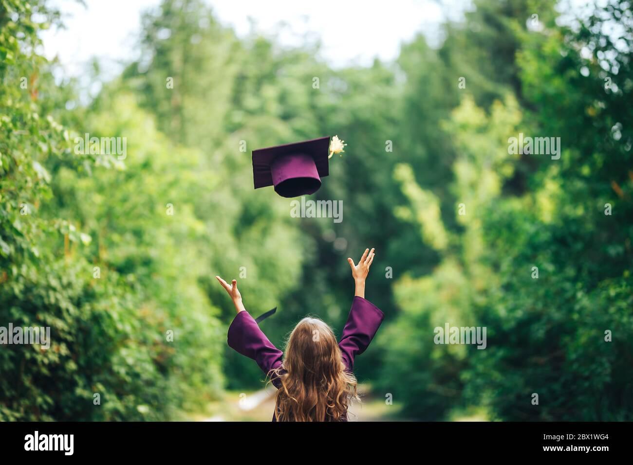 Photo from back graduate graduated little girl in cap throw it up in ...