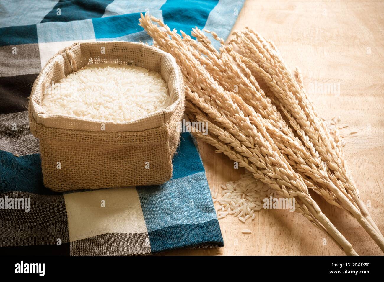 Raw rice grain and dry rice plant on wooden table background Stock ...