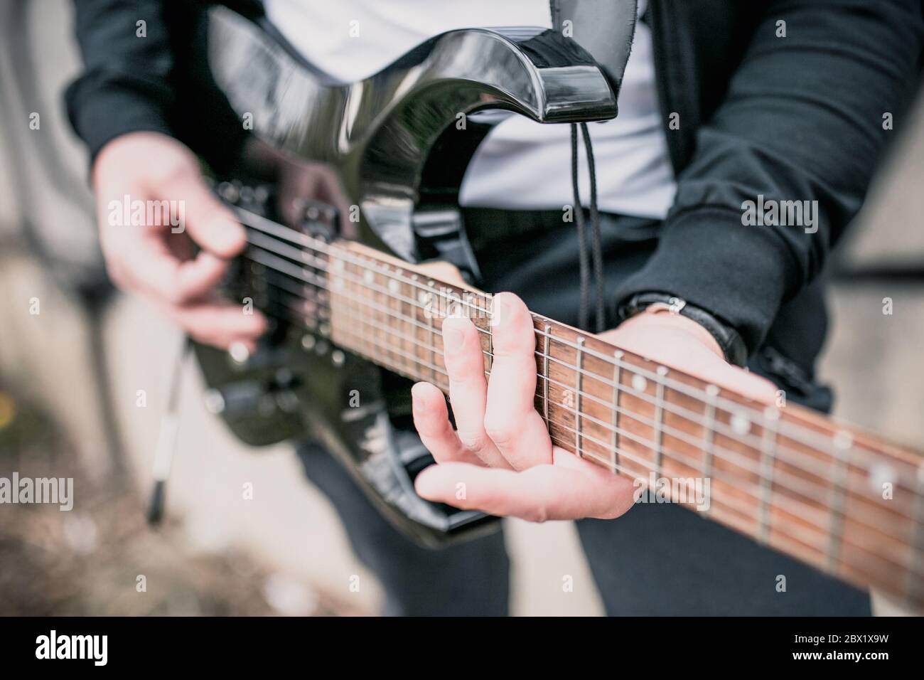 Technique of playing the electric guitar - a man playing outdoors ...