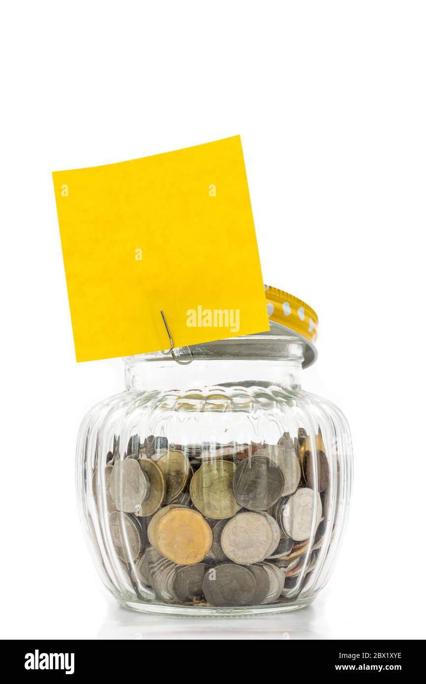 Coins in glass bottle with blank paper for text on white background ...