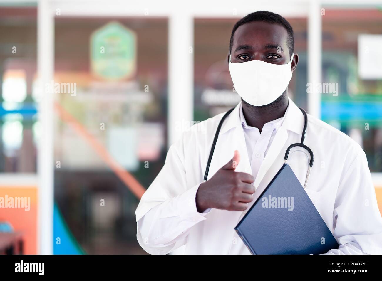 African doctor wear face mask and holding stethoscope and report book ...