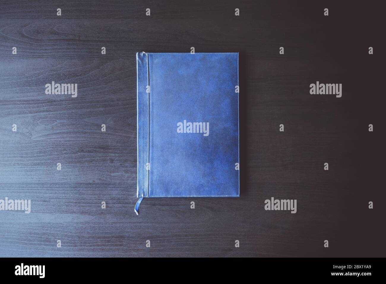 Top view of Old blue book on the black desk Stock Photo - Alamy