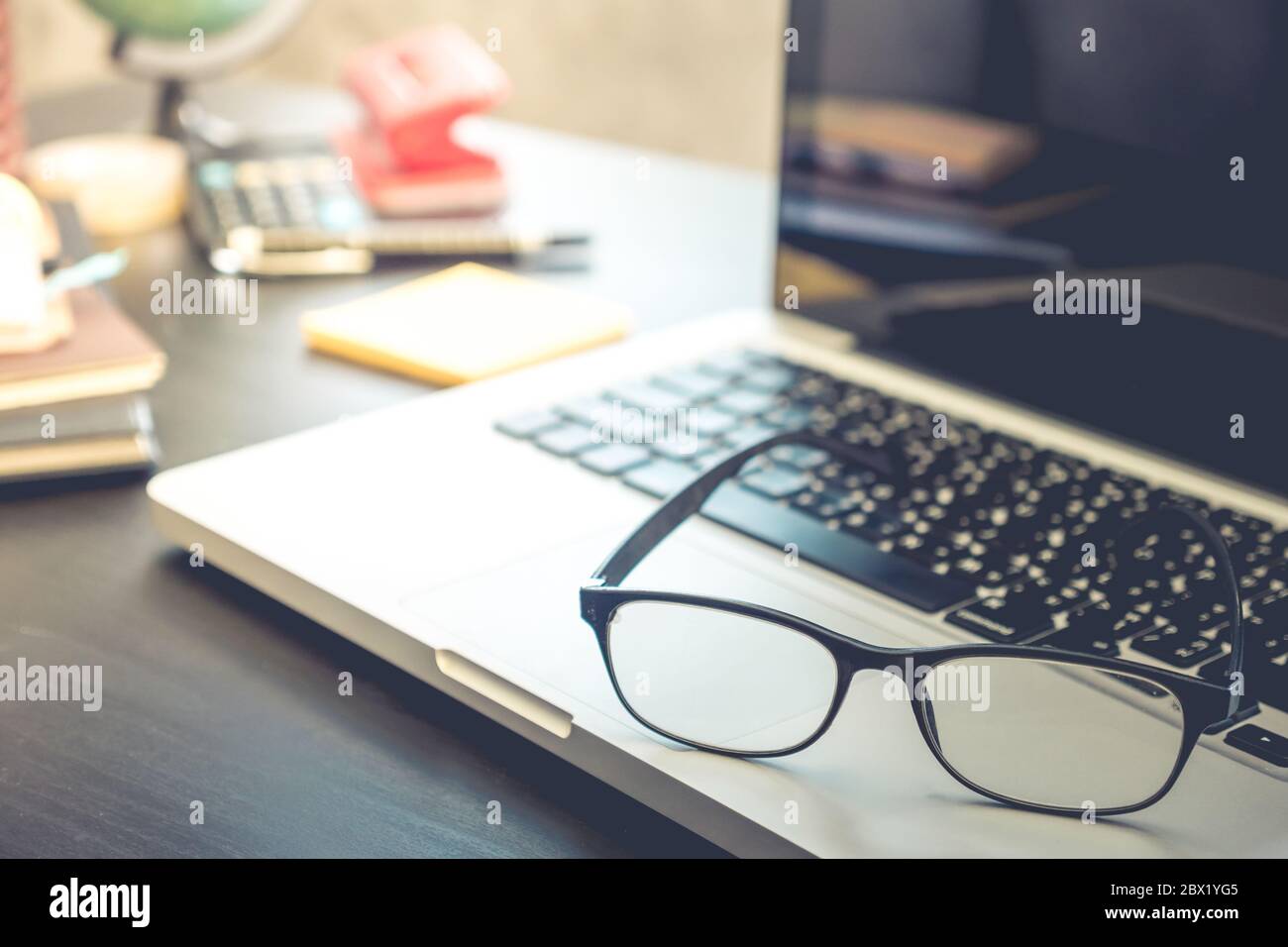 Eyeglasses with laptop on the desk Stock Photo - Alamy
