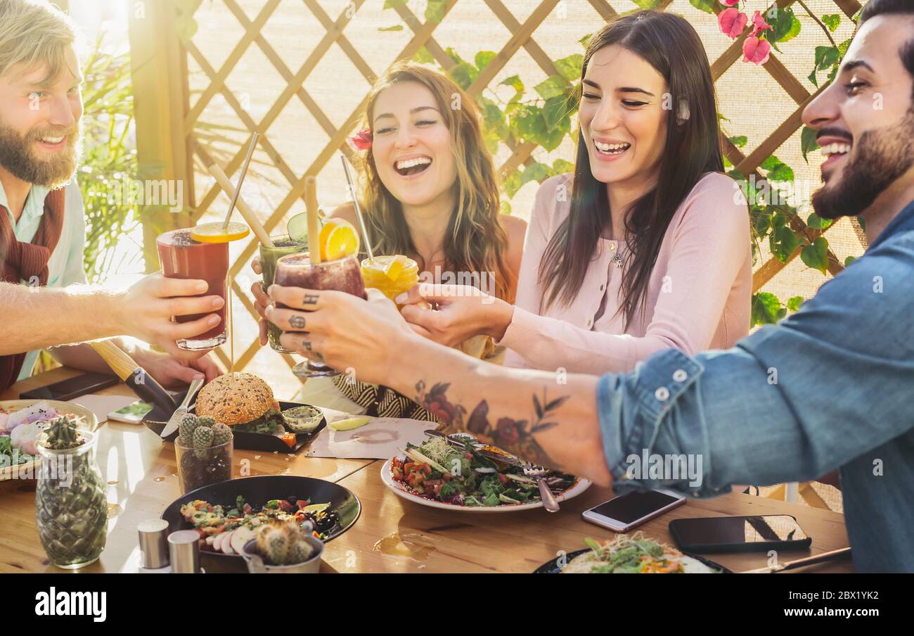 Happy friends lunching healthy food and drinking smoothies fresh fruits ...