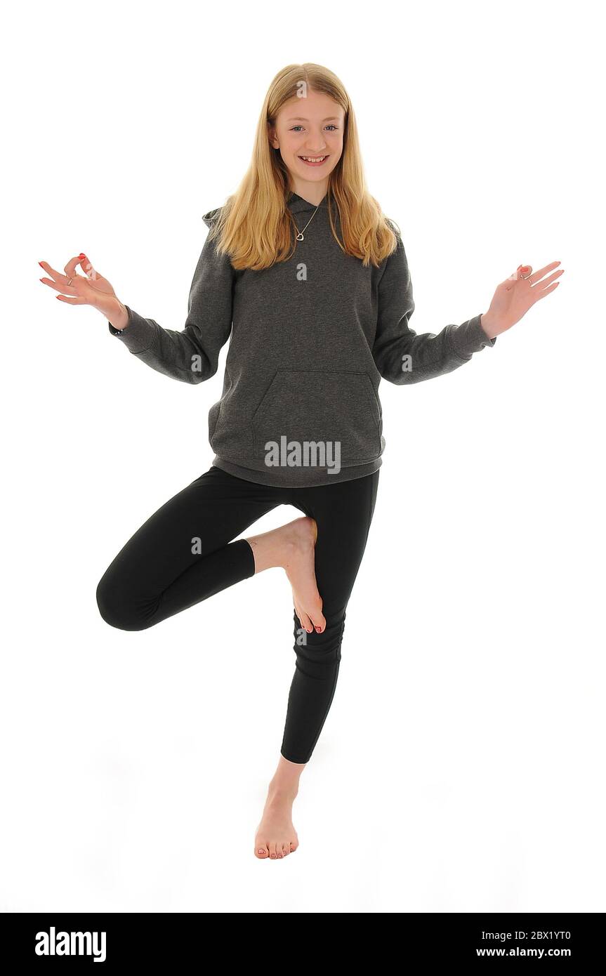 pretty blonde teenage girl standing on one foot in a yoga pose ...