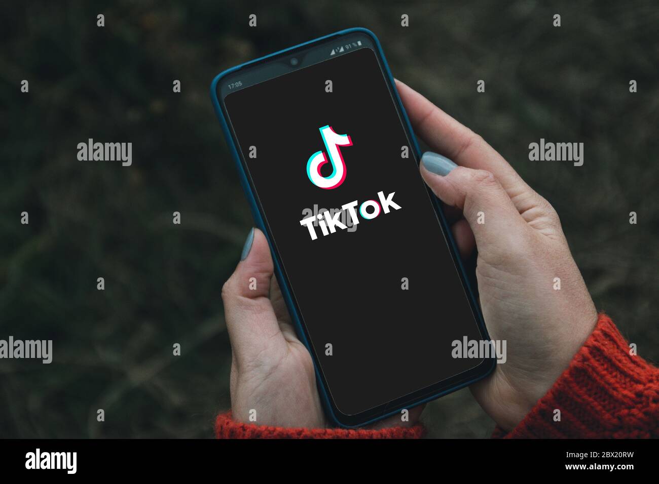 Woman using smartphone Tik Tok application on screen, Tik tok is ...