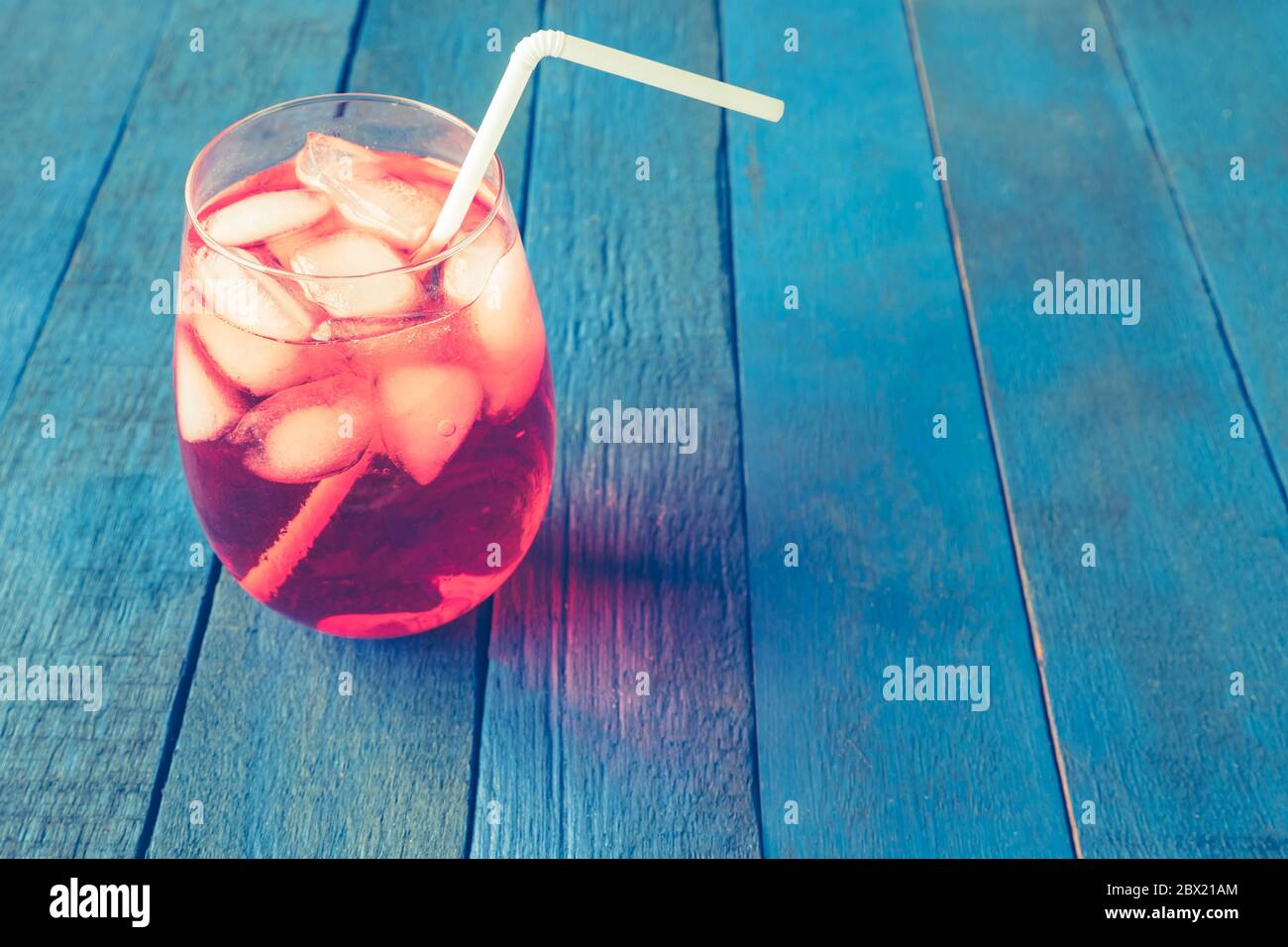 Red cocktail with ice cubes on blue painted wood plank background Stock ...