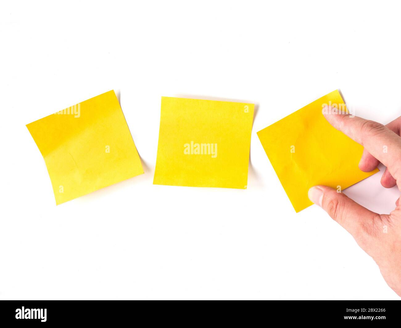 Yellow stick notes paper with hand on white background Stock Photo - Alamy