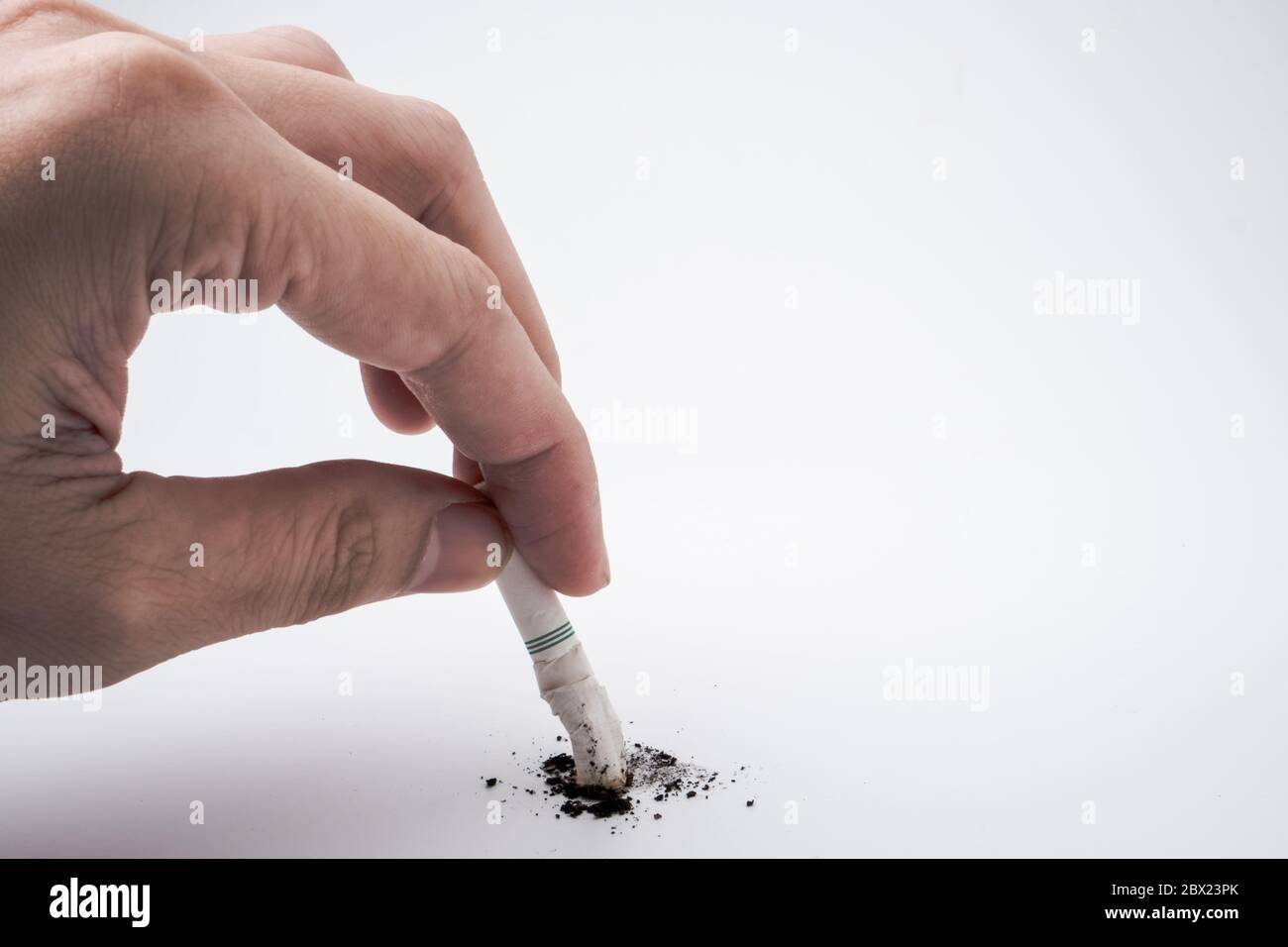 A hand push the cigarette stub on white background, Symbolic stop ...