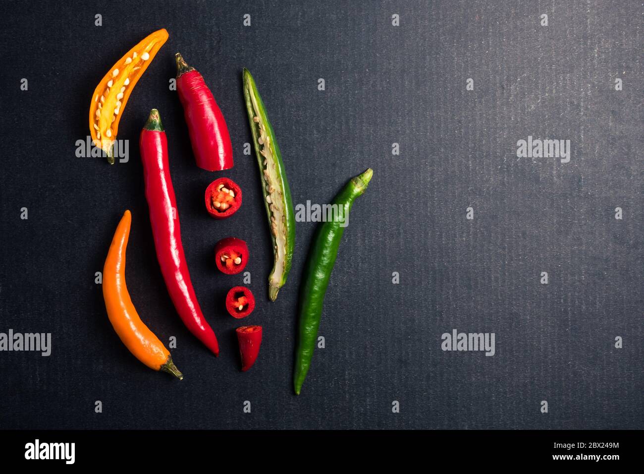 Colorful mix of chili pappers on black background. Free space for text ...
