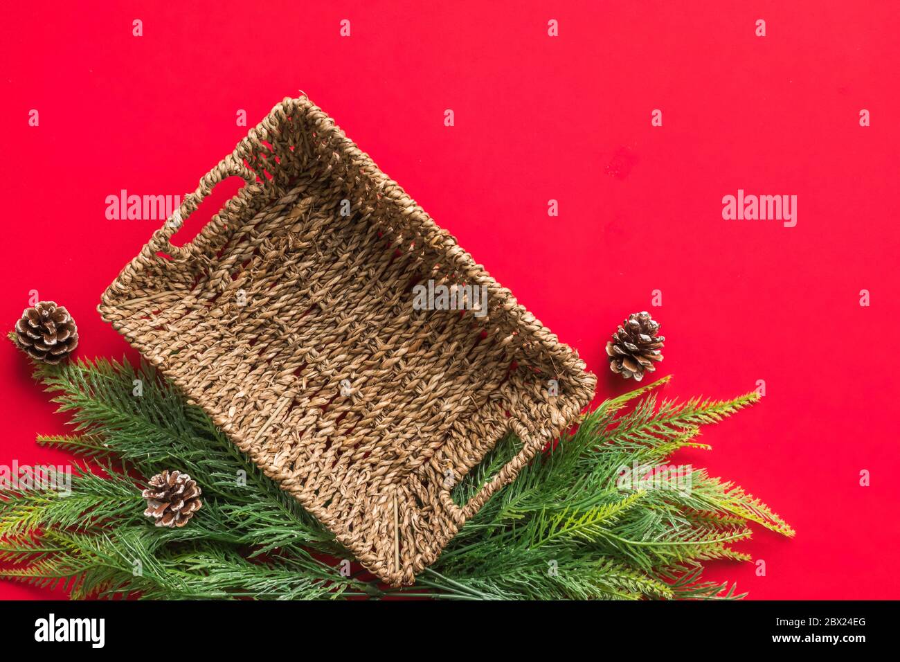 Empty basket with christmas tree branches on red background. Free space ...
