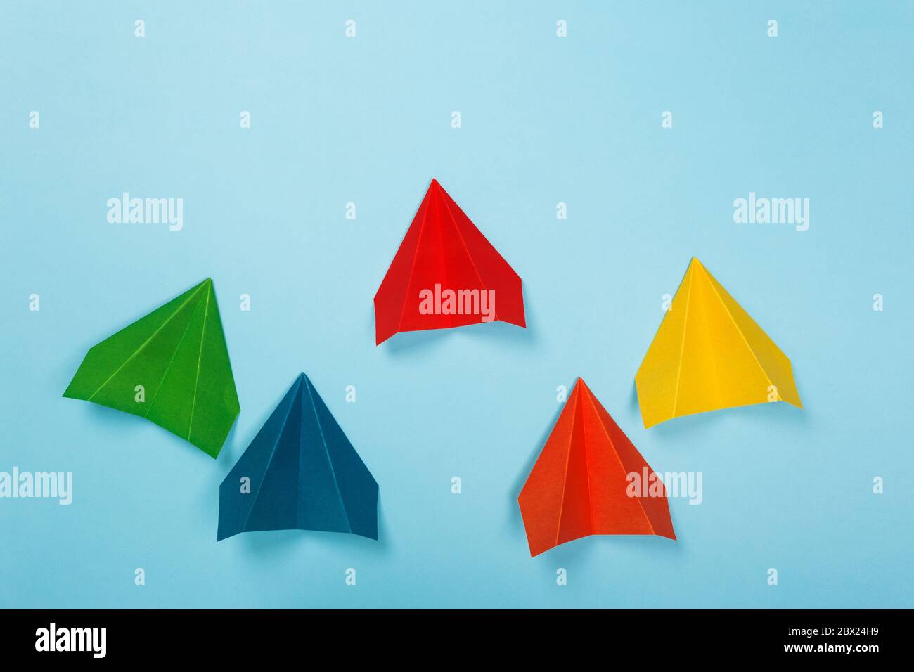 Color paper airplanes on blue background. top view Stock Photo - Alamy