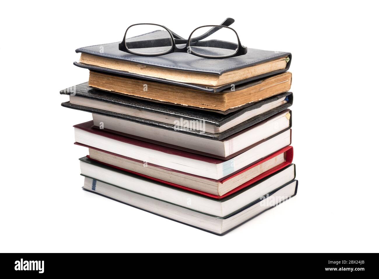 A stack of books with eyeglasses on a white background Stock Photo - Alamy