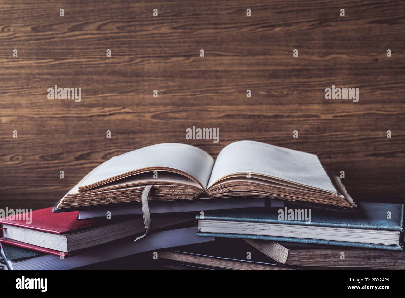Open book, hardback books on wood wall background. Free space for text ...