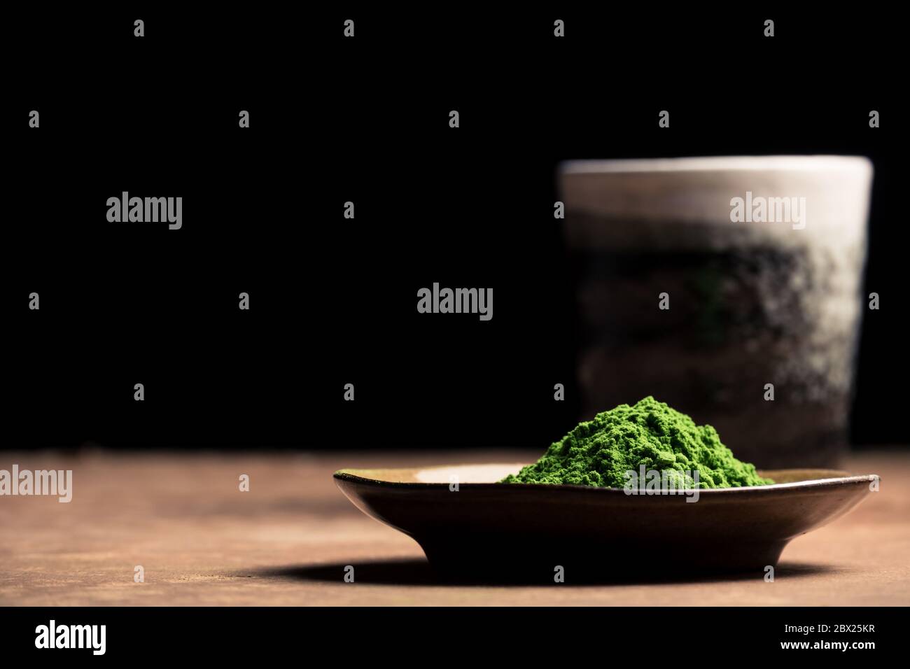 Green tea powder with ceramic cup on the table, black background. Free ...