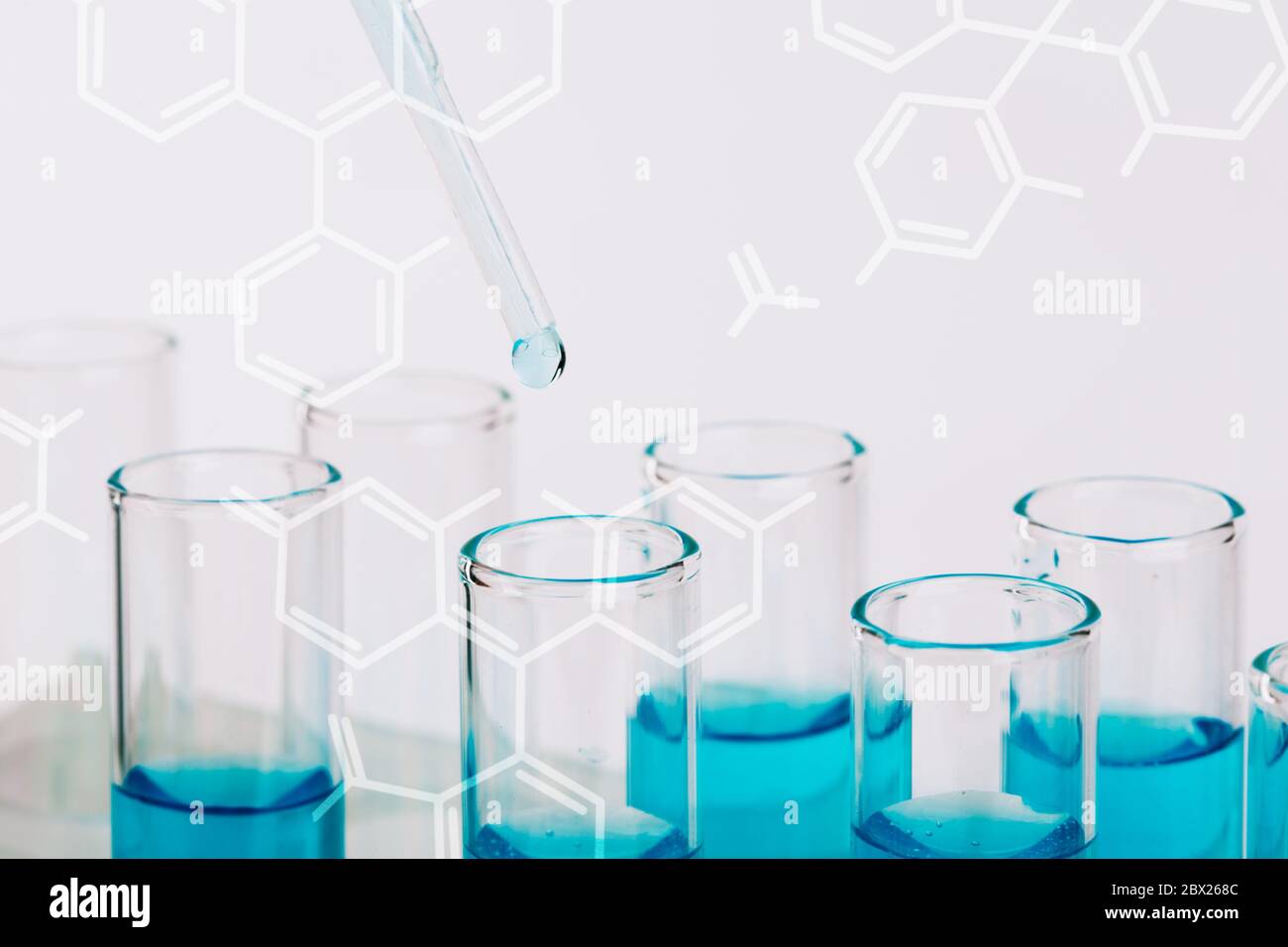 Laboratory glassware with a dropper dripping liquid into a test tube ...