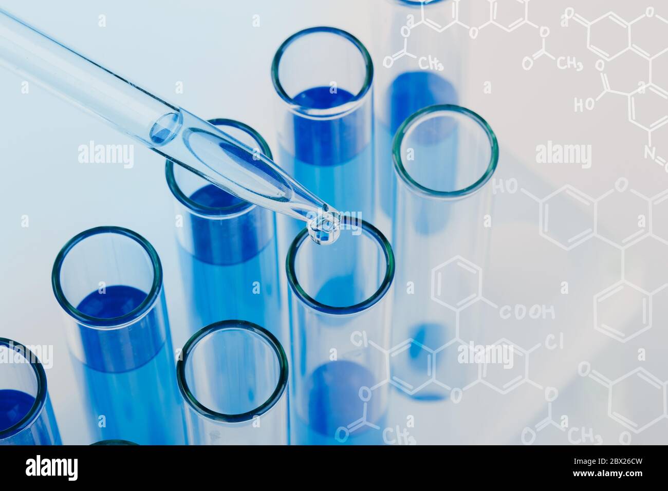 Laboratory glassware with a dropper dripping liquid into a test tube ...