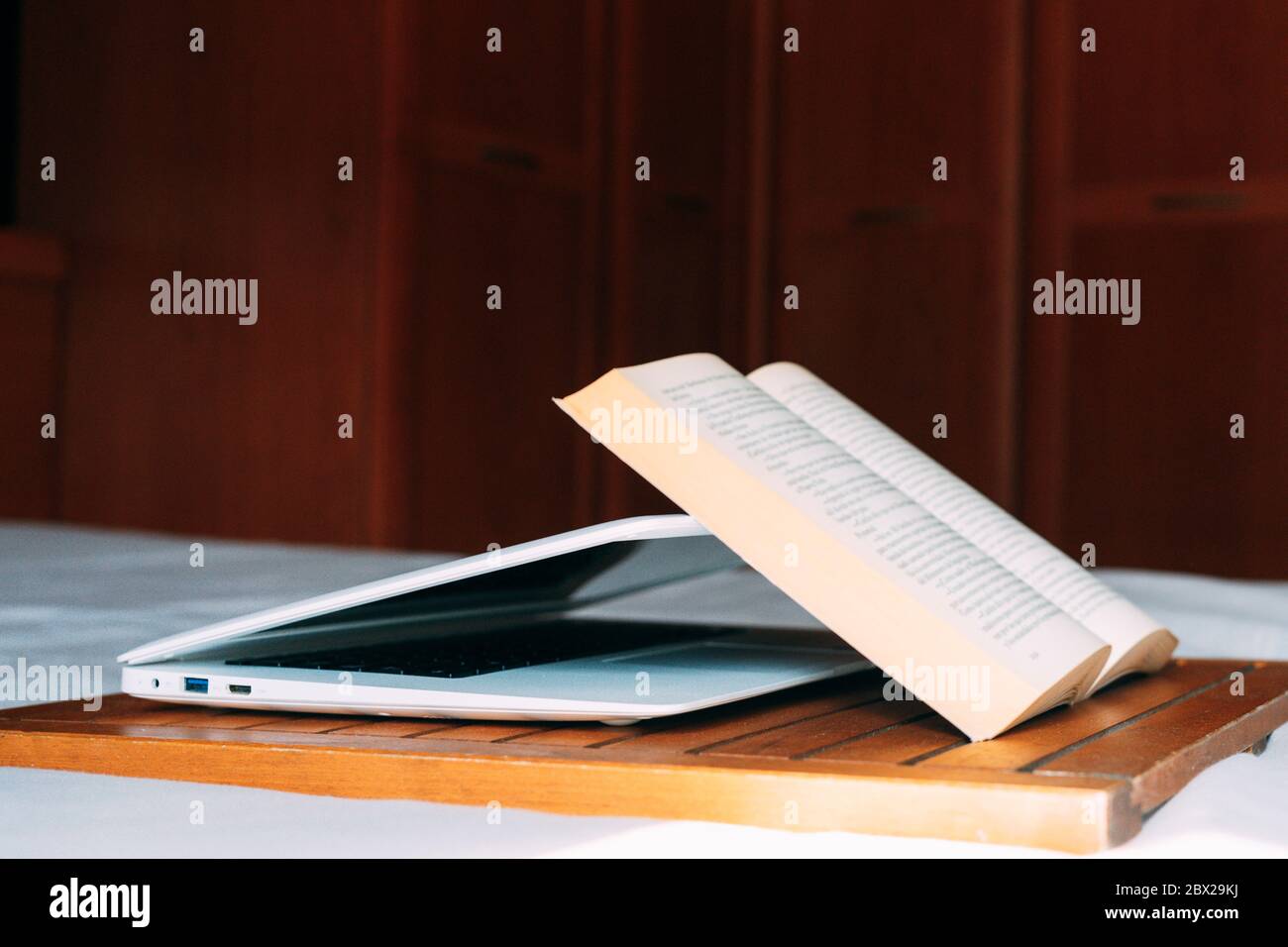 Book on top of a computer. Digital detox Stock Photo - Alamy