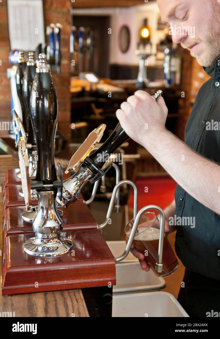 bartender pulling beer at British pub Stock Photo - Alamy