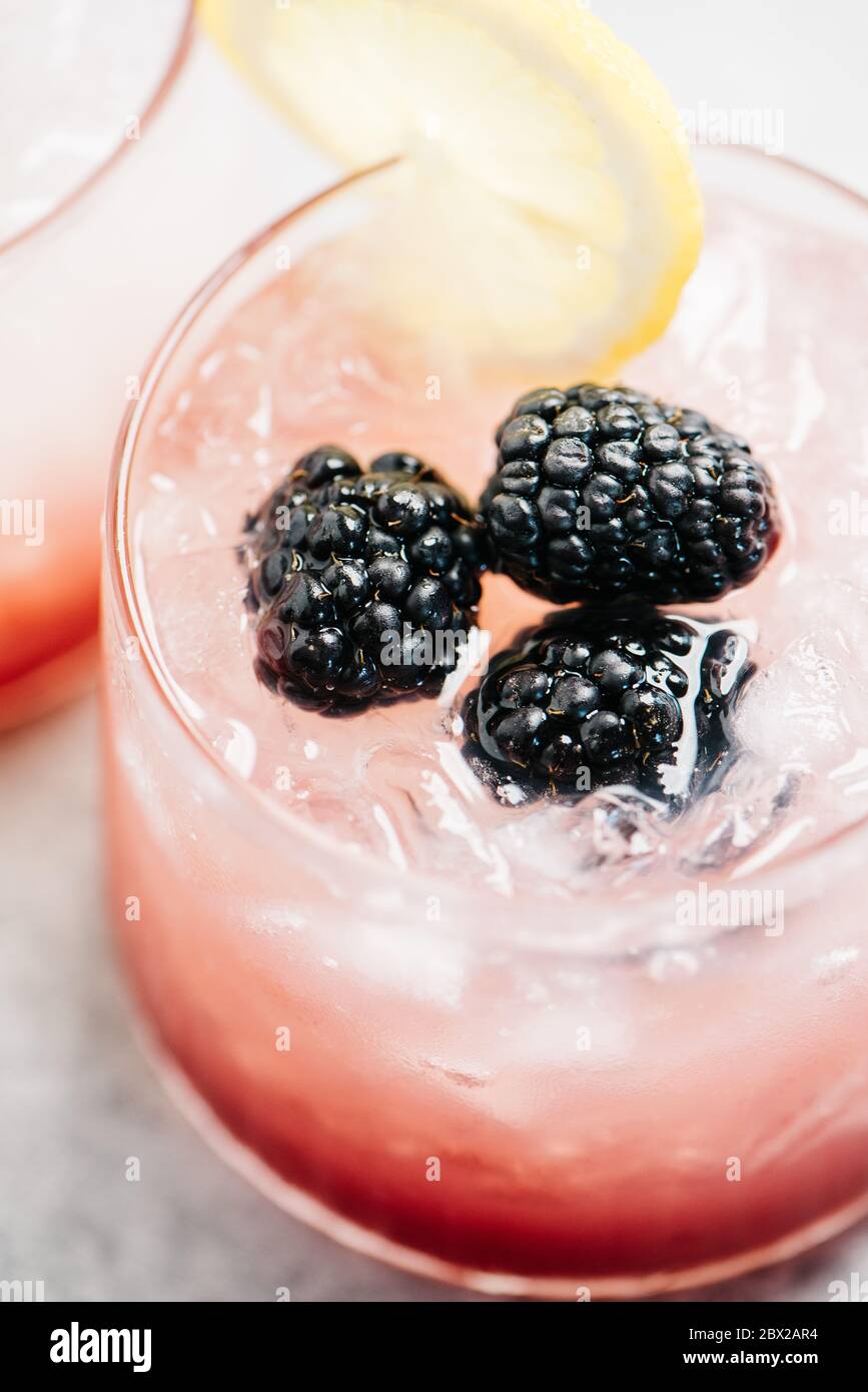 High angle detail of a Bramble cocktail with blackberries and lemon ...