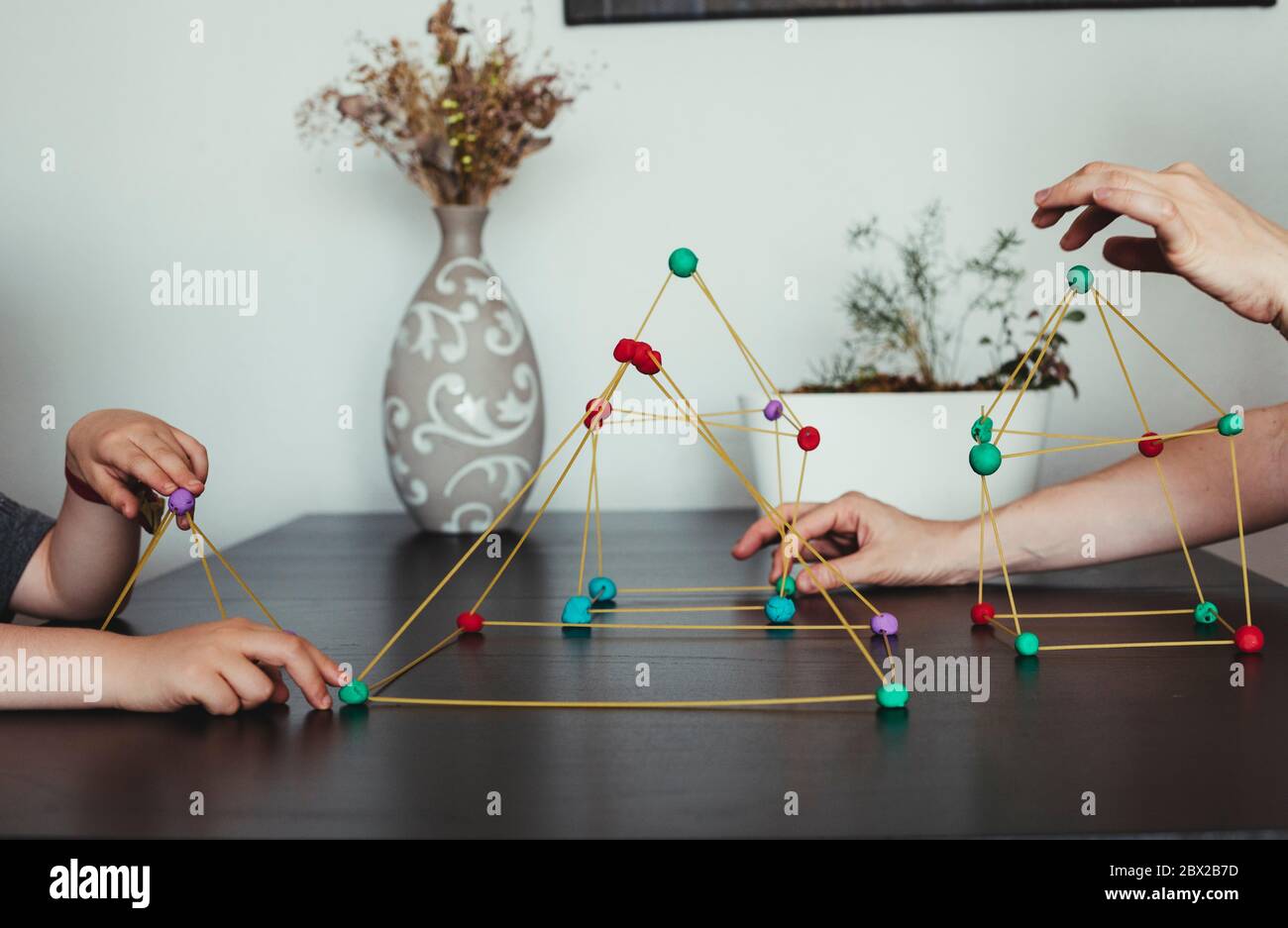 Mother and son making geometric shapes from sticks and play dough Stock ...